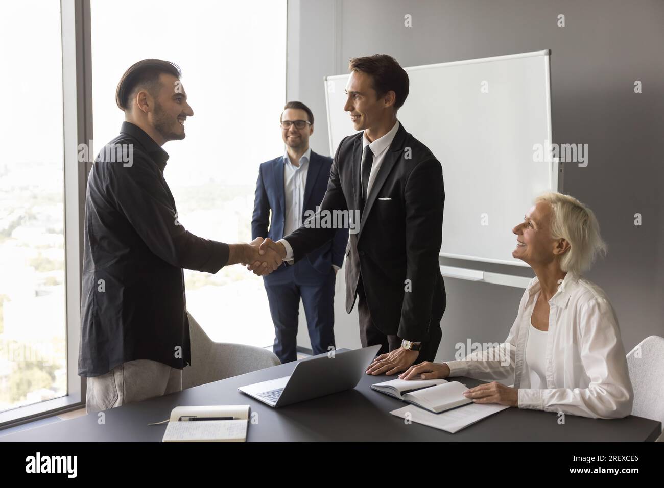 Boss expressing recognition to best manager, employee, giving handshake ...