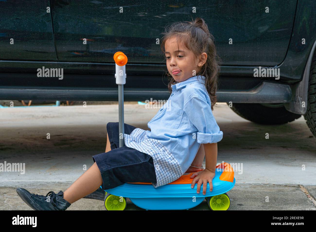 A cute boy with long hair rides a scooter He had a mischievous glint in ...