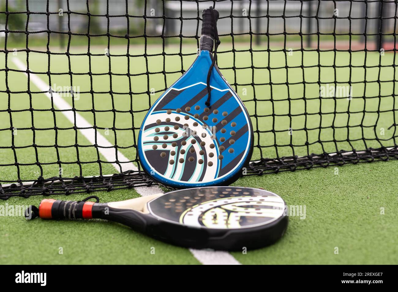 White professional paddle tennis racket with natural lighting on blue ...