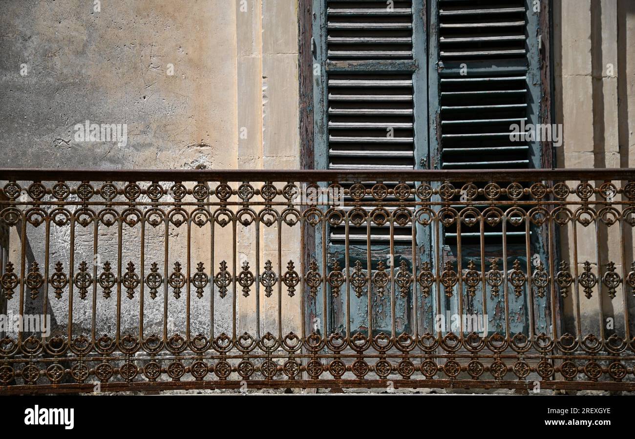 Antique Neoclassical style building balcony with a rusty wrought iron ...