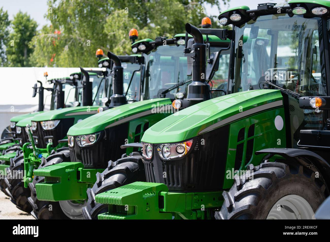 A row of green agricultural tractors Stock Photo - Alamy
