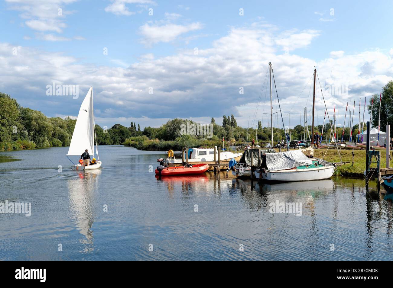 A small yacht sailing on the River Thames at Shepperton on a sunny ...