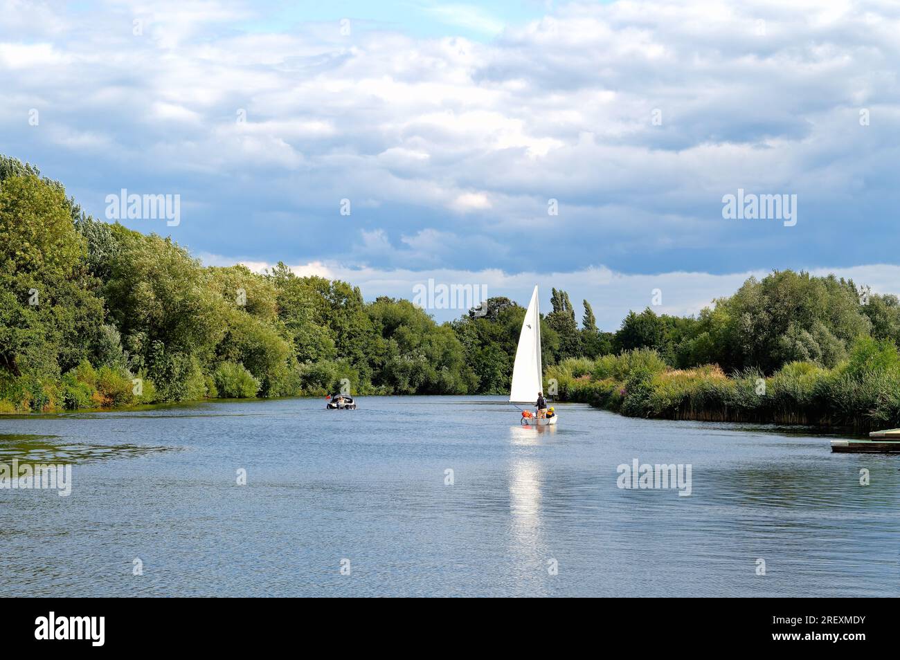 A small yacht sailing on the River Thames at Shepperton on a sunny ...