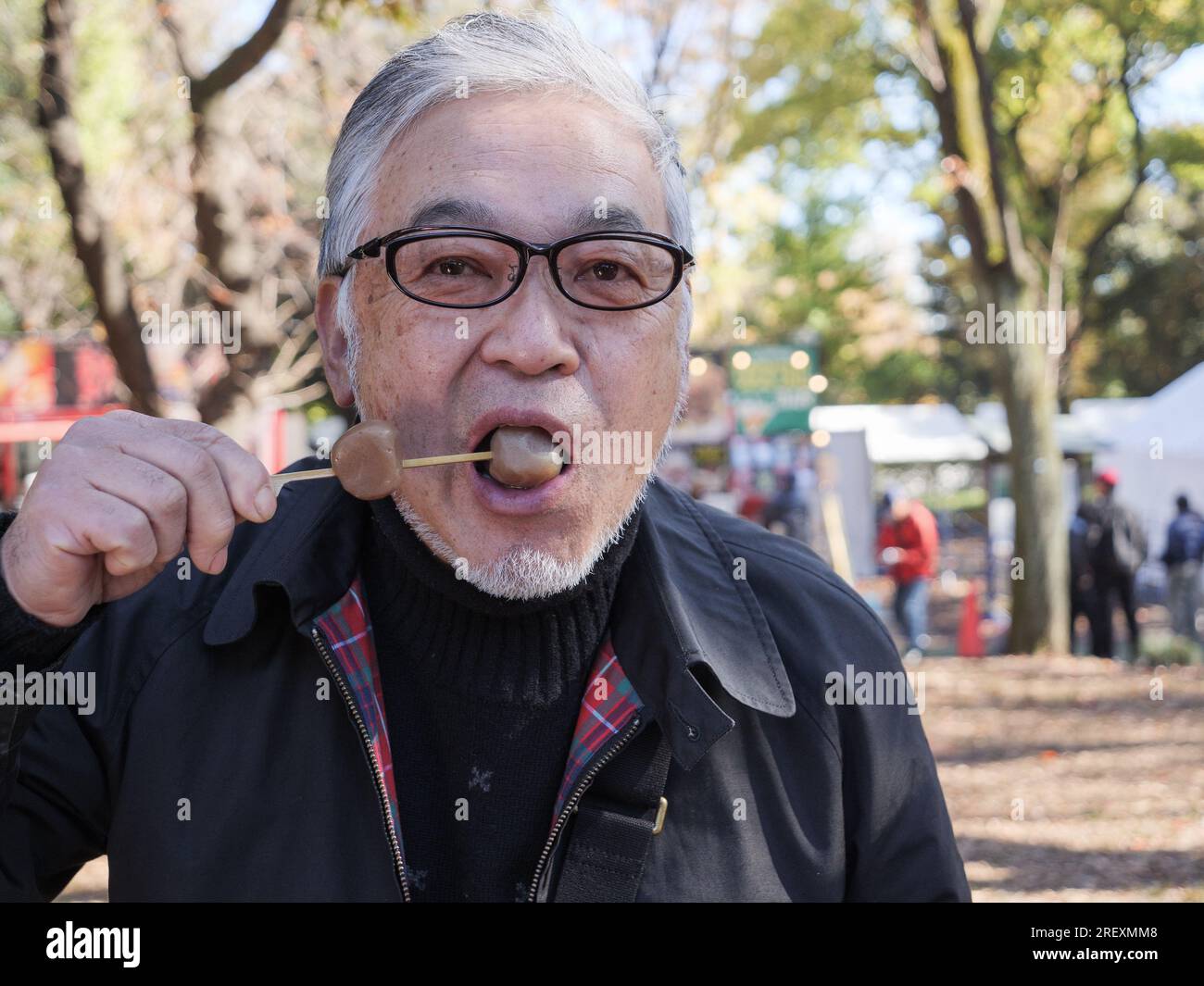 An asian man in glasses eating dango Stock Photo - Alamy