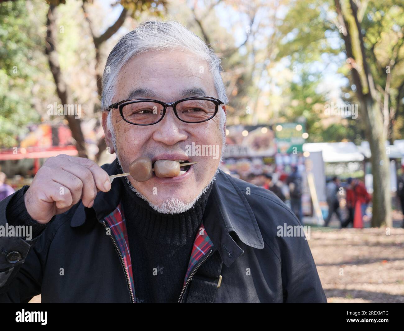 An asian man in glasses eating dango Stock Photo - Alamy