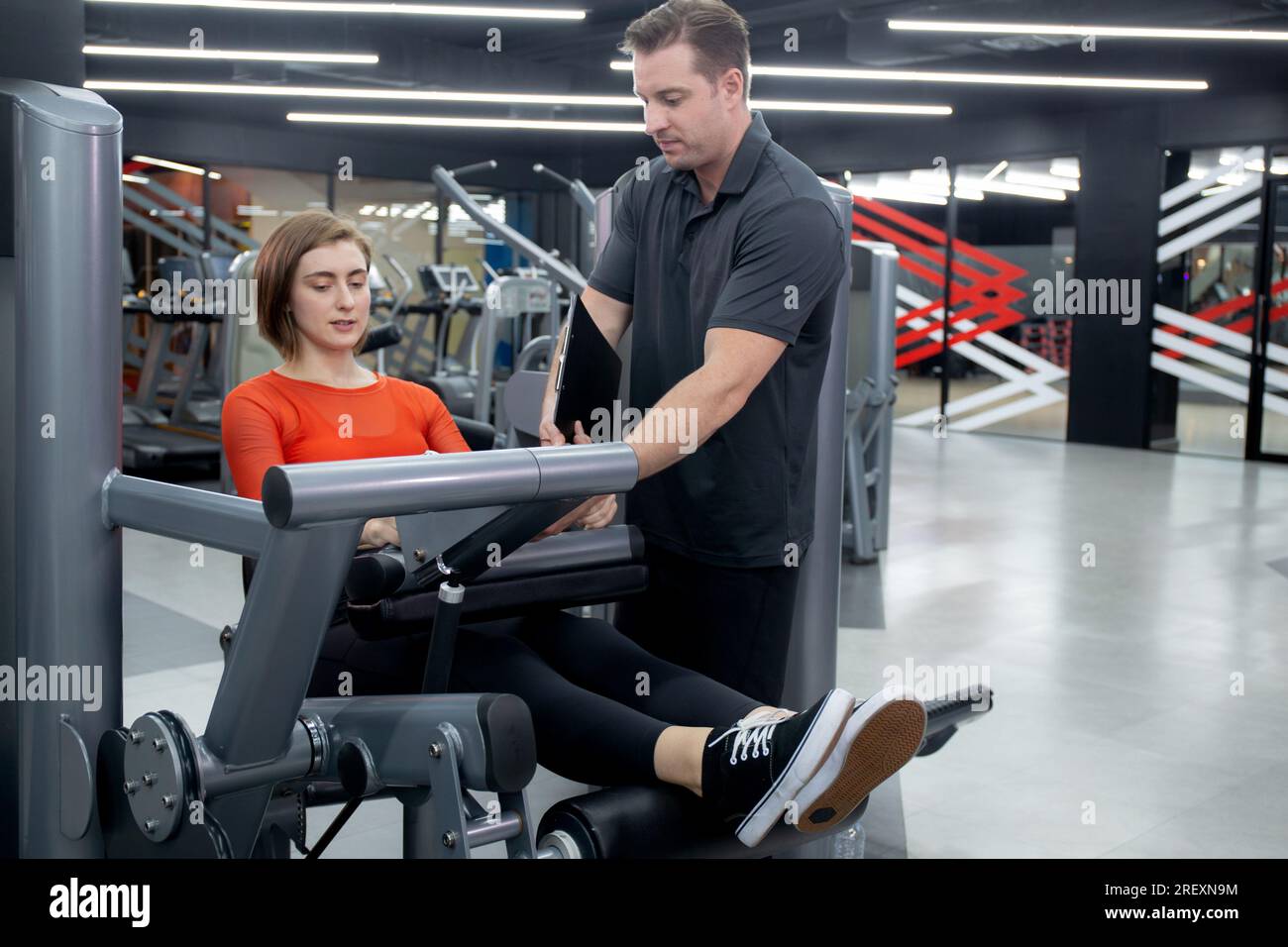 Coach man guidance workout with legs muscles stretch with equipment ...