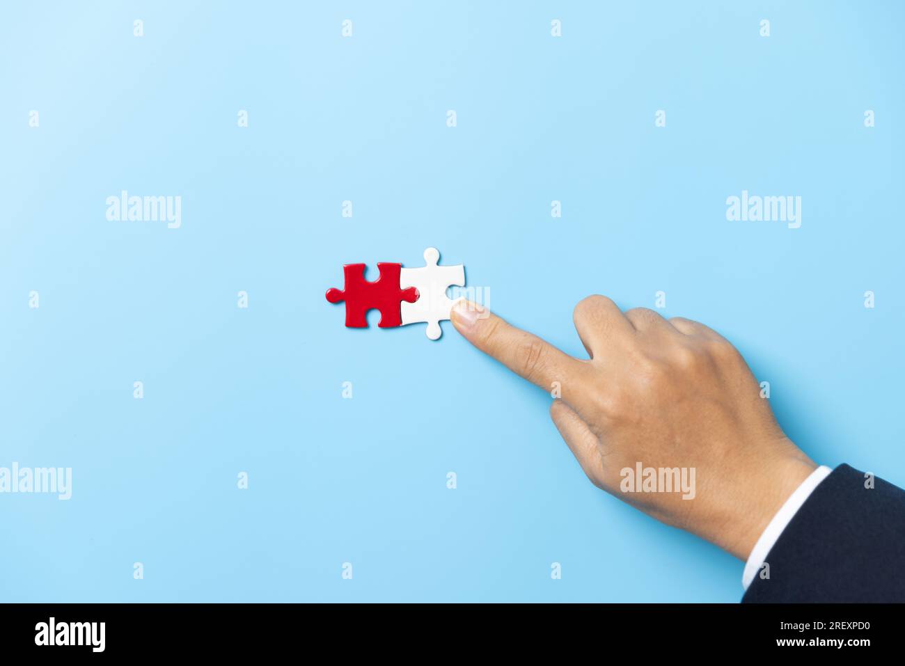 Two hands trying to connect couple puzzle piece on blue background ...