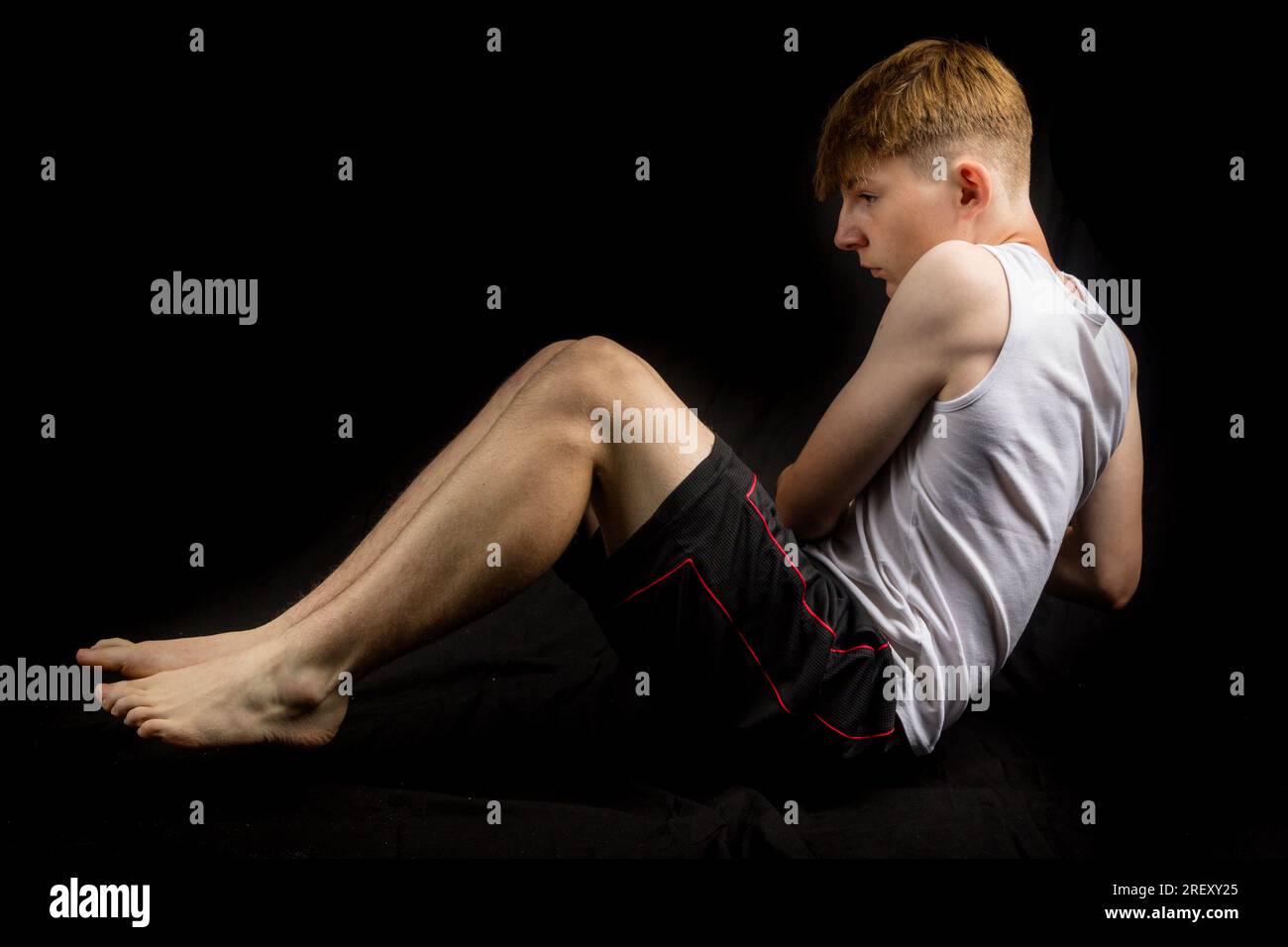Portrait of a 14 year old caucasian teenage boy wearing a sleeveless ...
