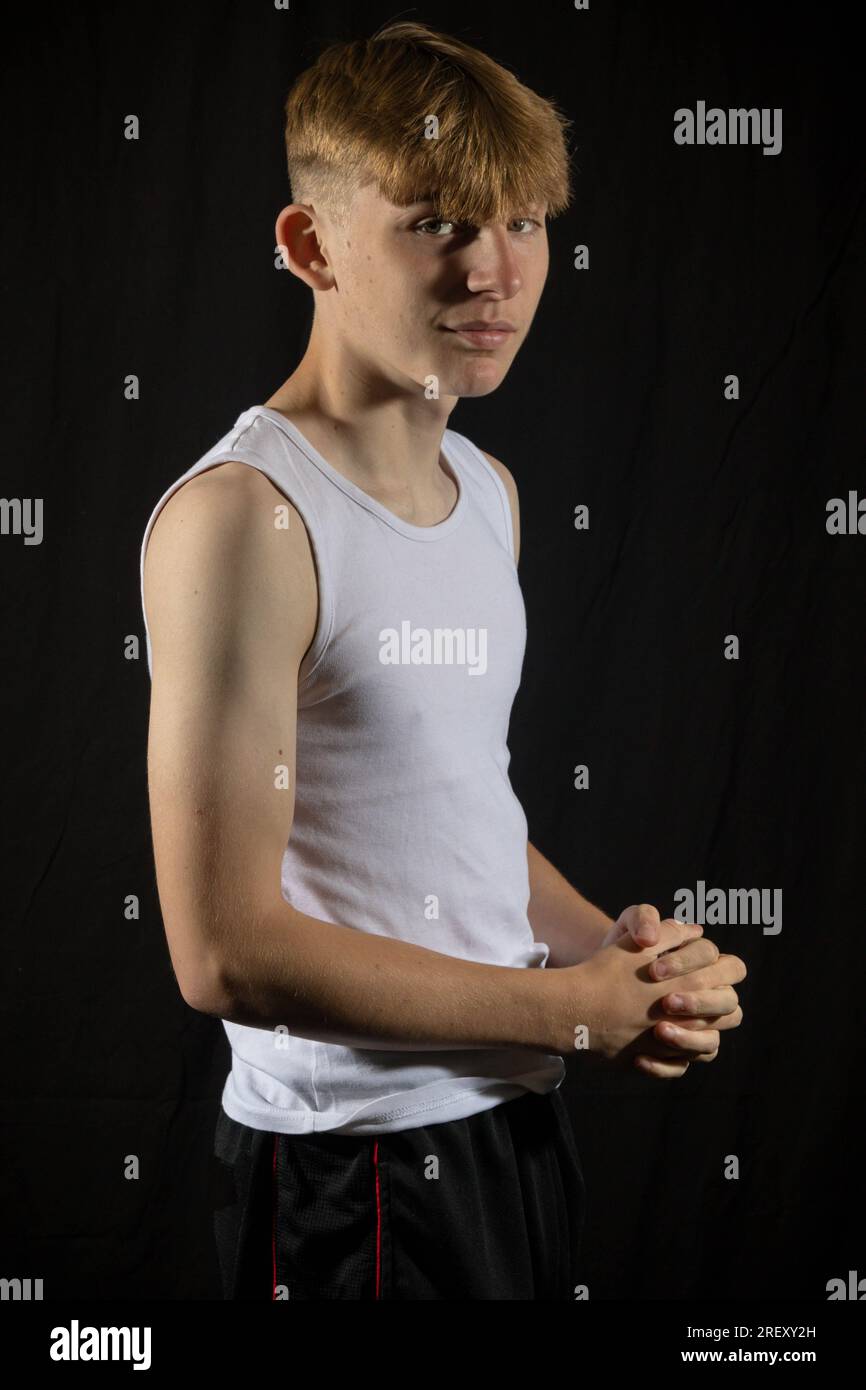 Portrait of a 14 year old caucasian teenage boy wearing a sleeveless ...