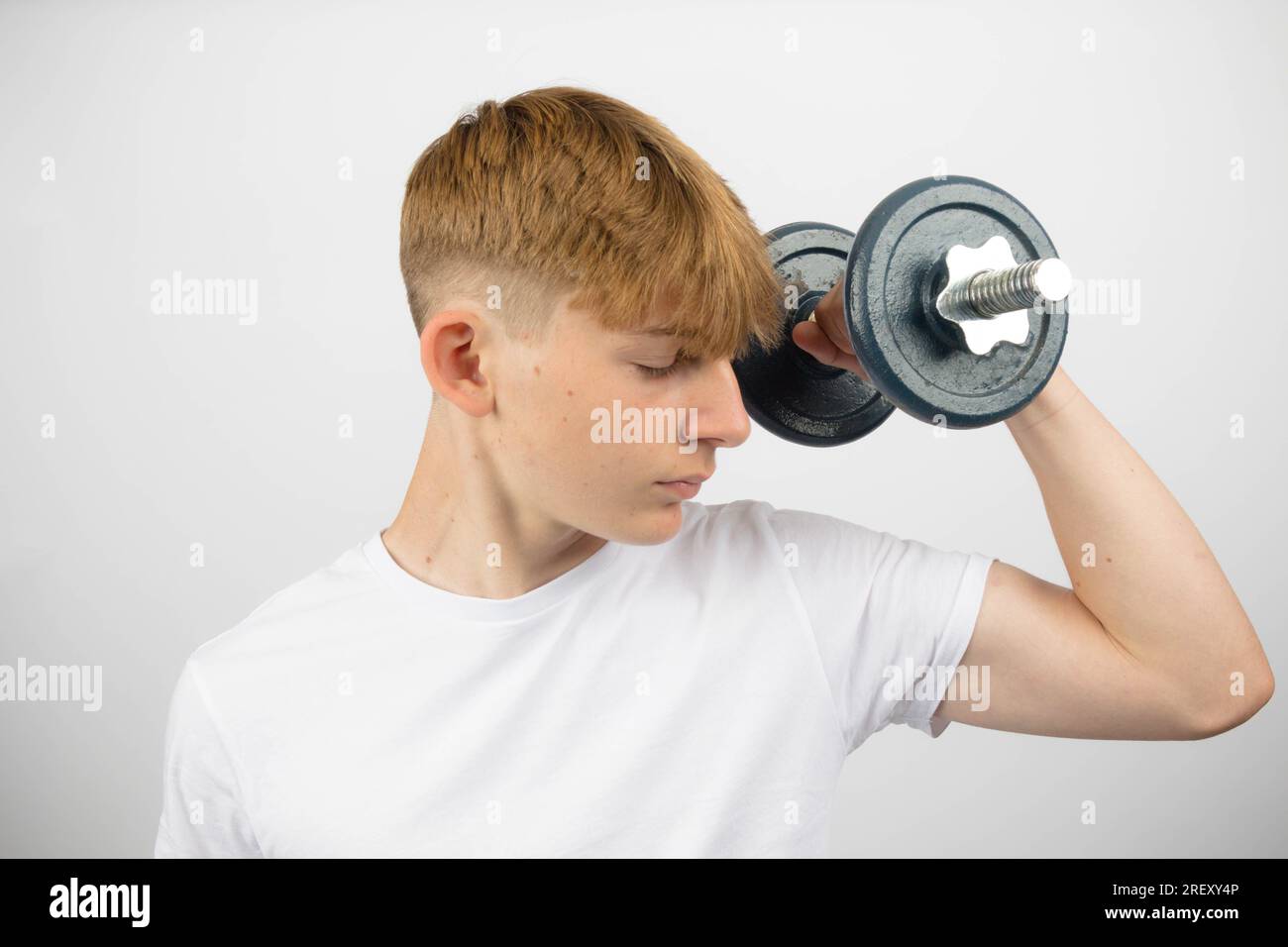 Portrait of a 14 year old caucasian teenage boy exercising with a ...