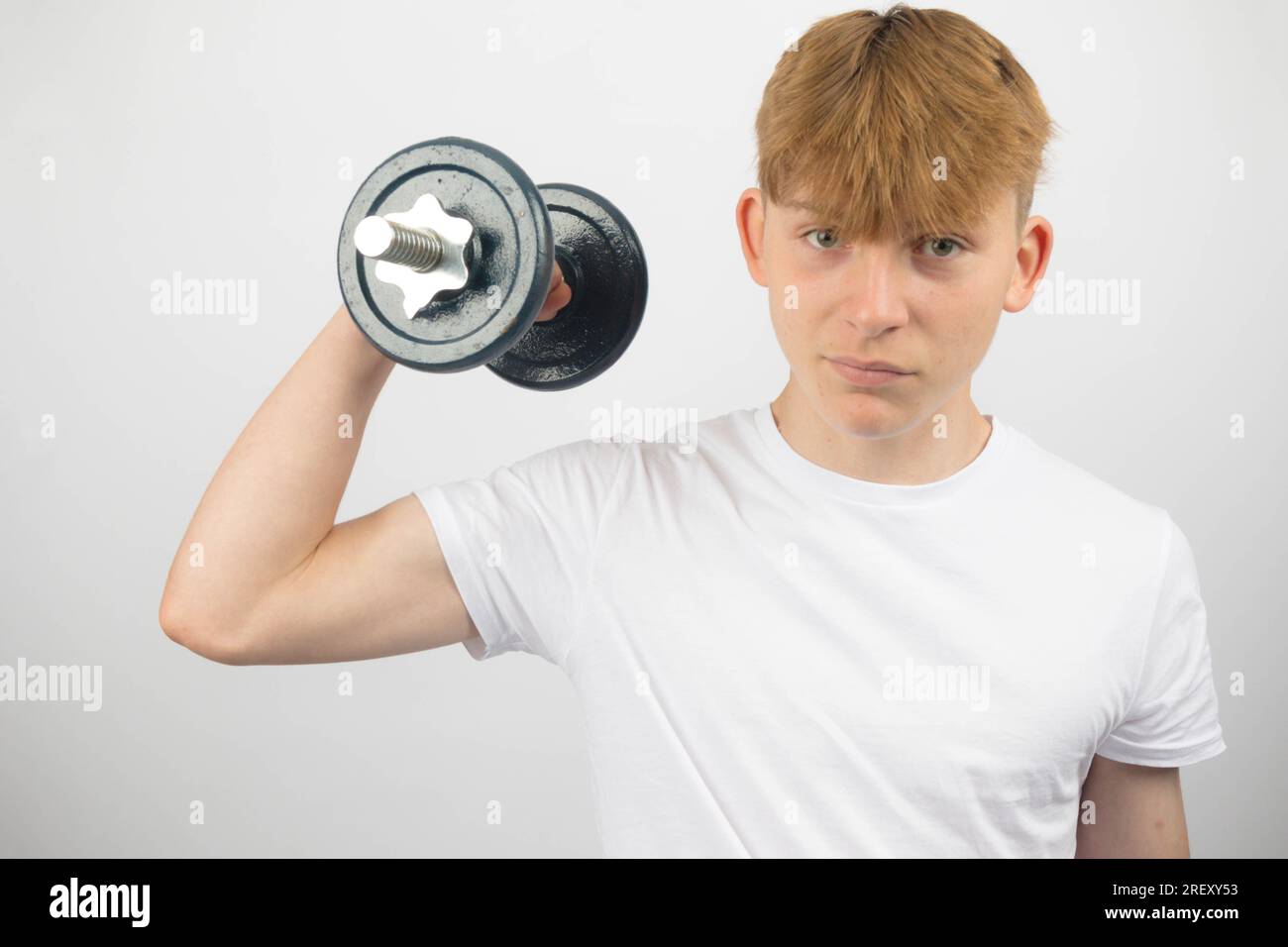 Portrait of a 14 year old caucasian teenage boy exercising with a ...