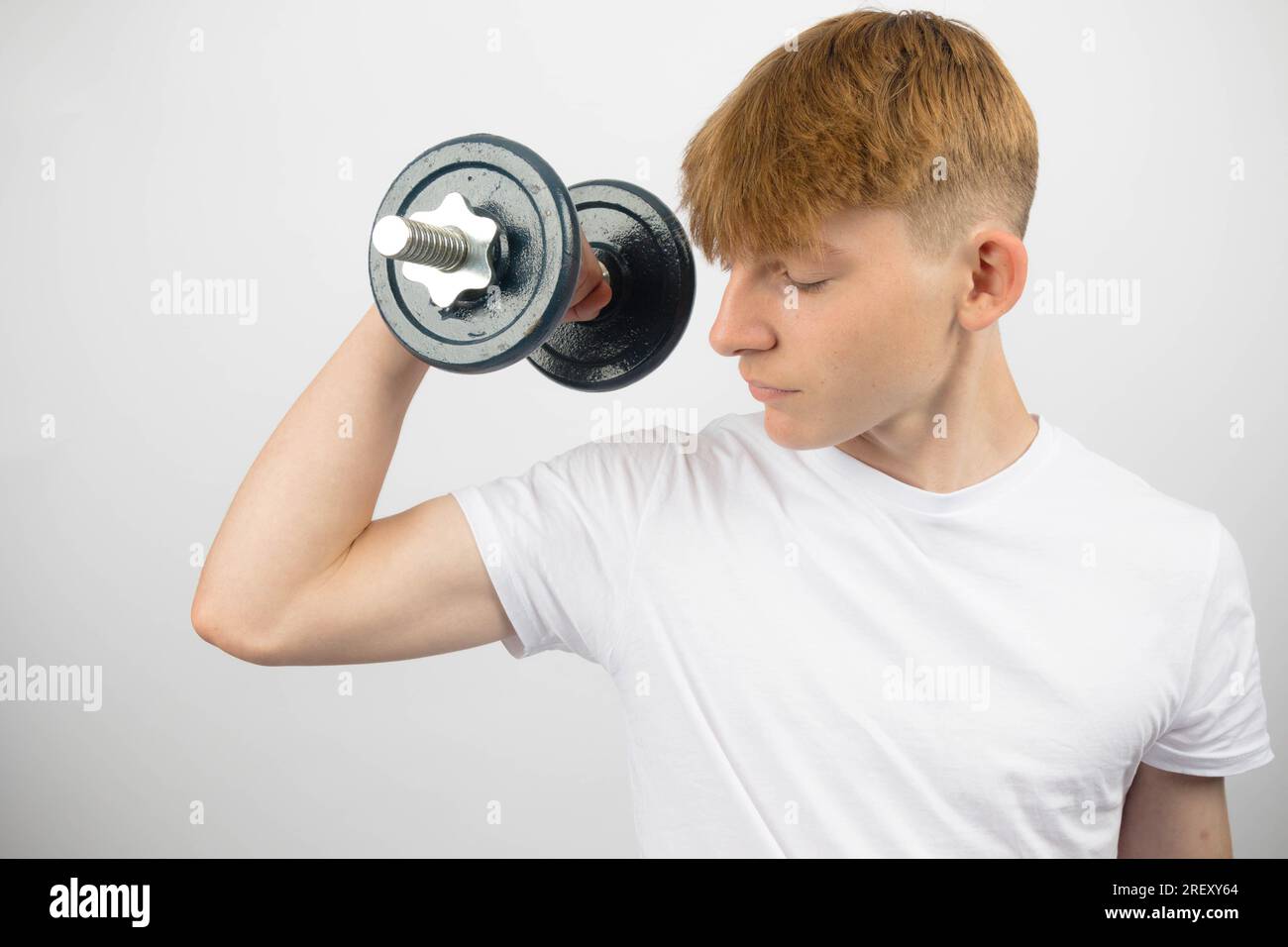 Portrait of a 14 year old caucasian teenage boy exercising with a ...