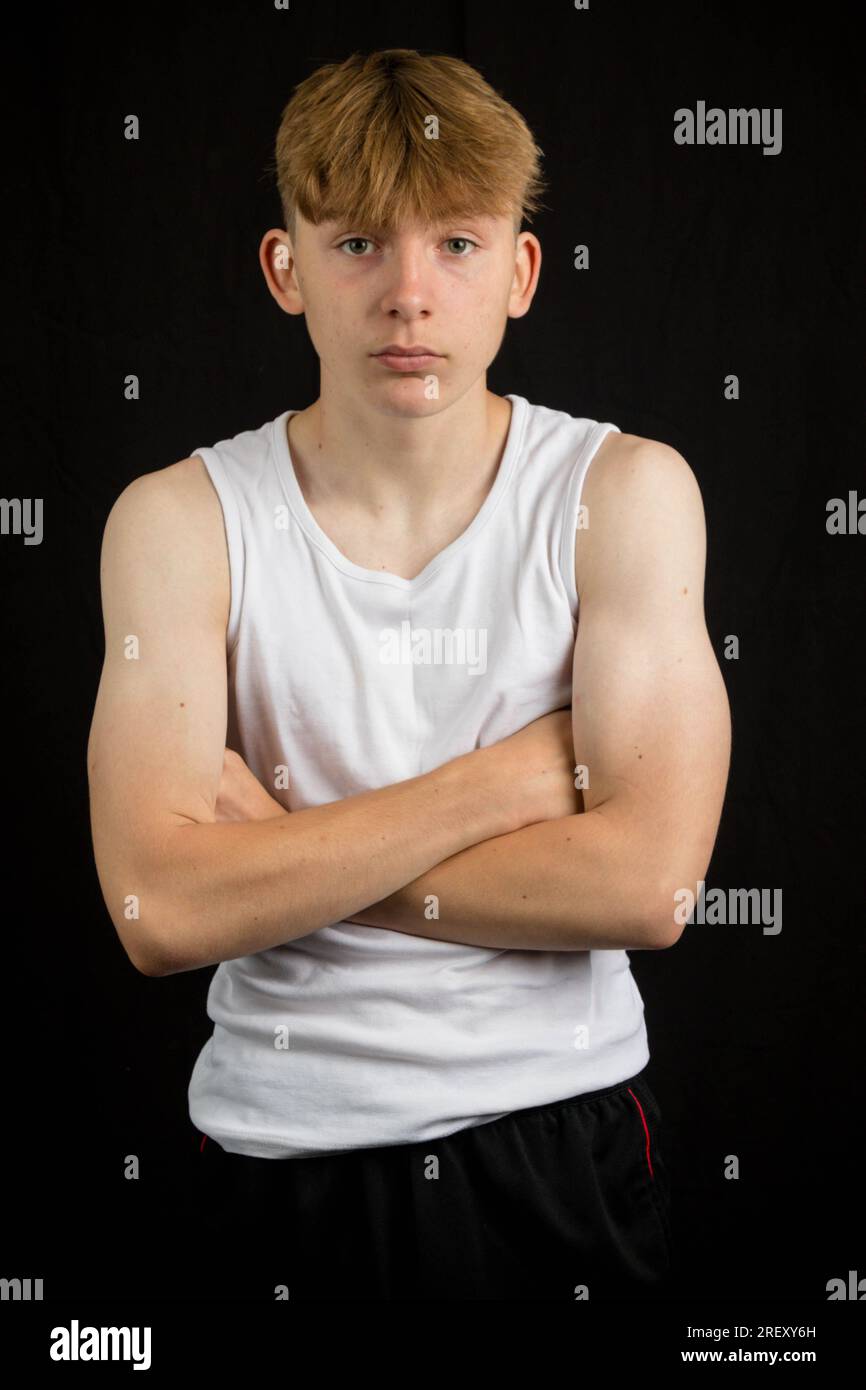 Portrait of a 14 year old caucasian teenage boy wearing a sleeveless ...
