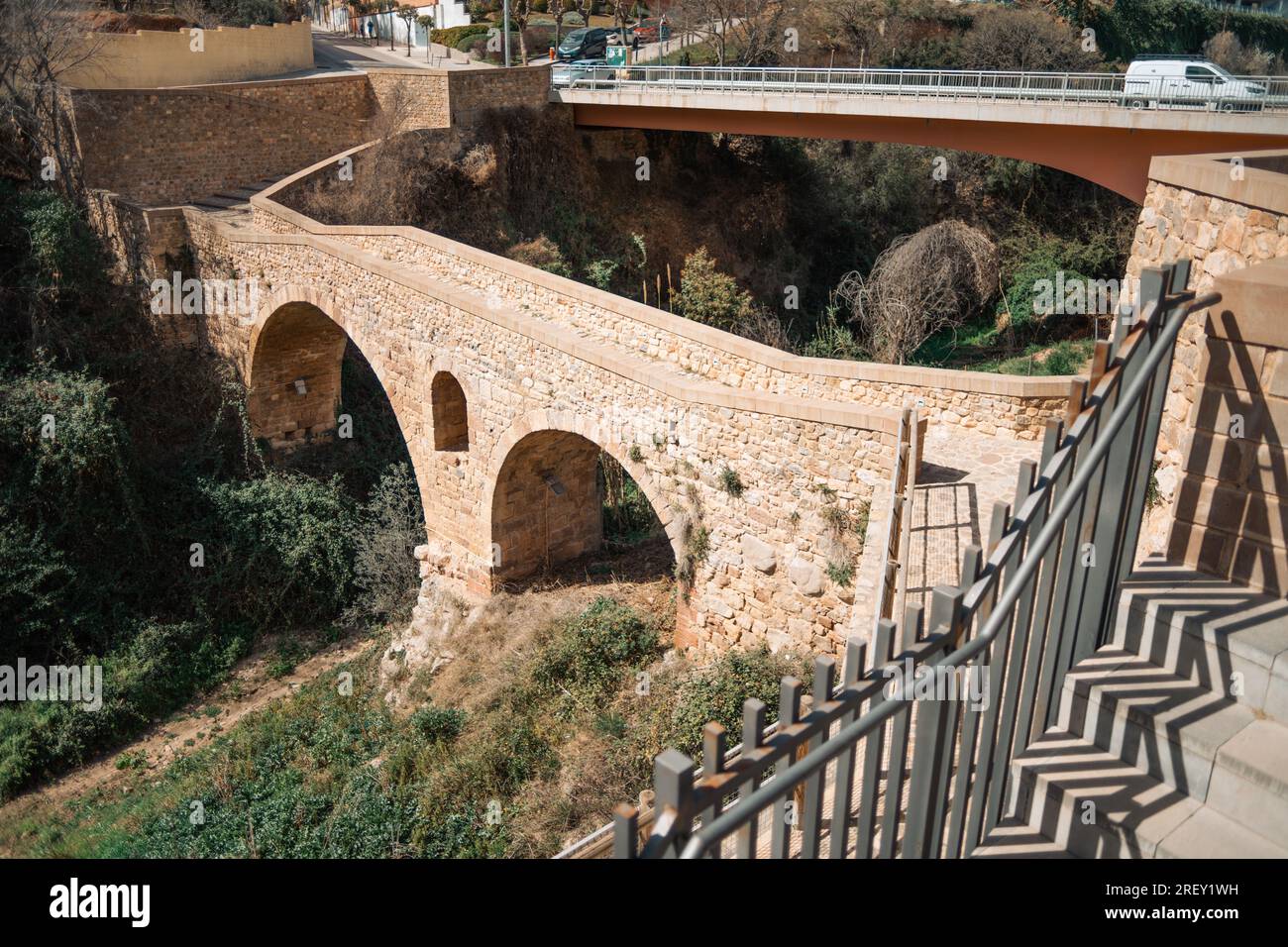 Wide-angle outdoor view of two bridges over a dry channel depression ...