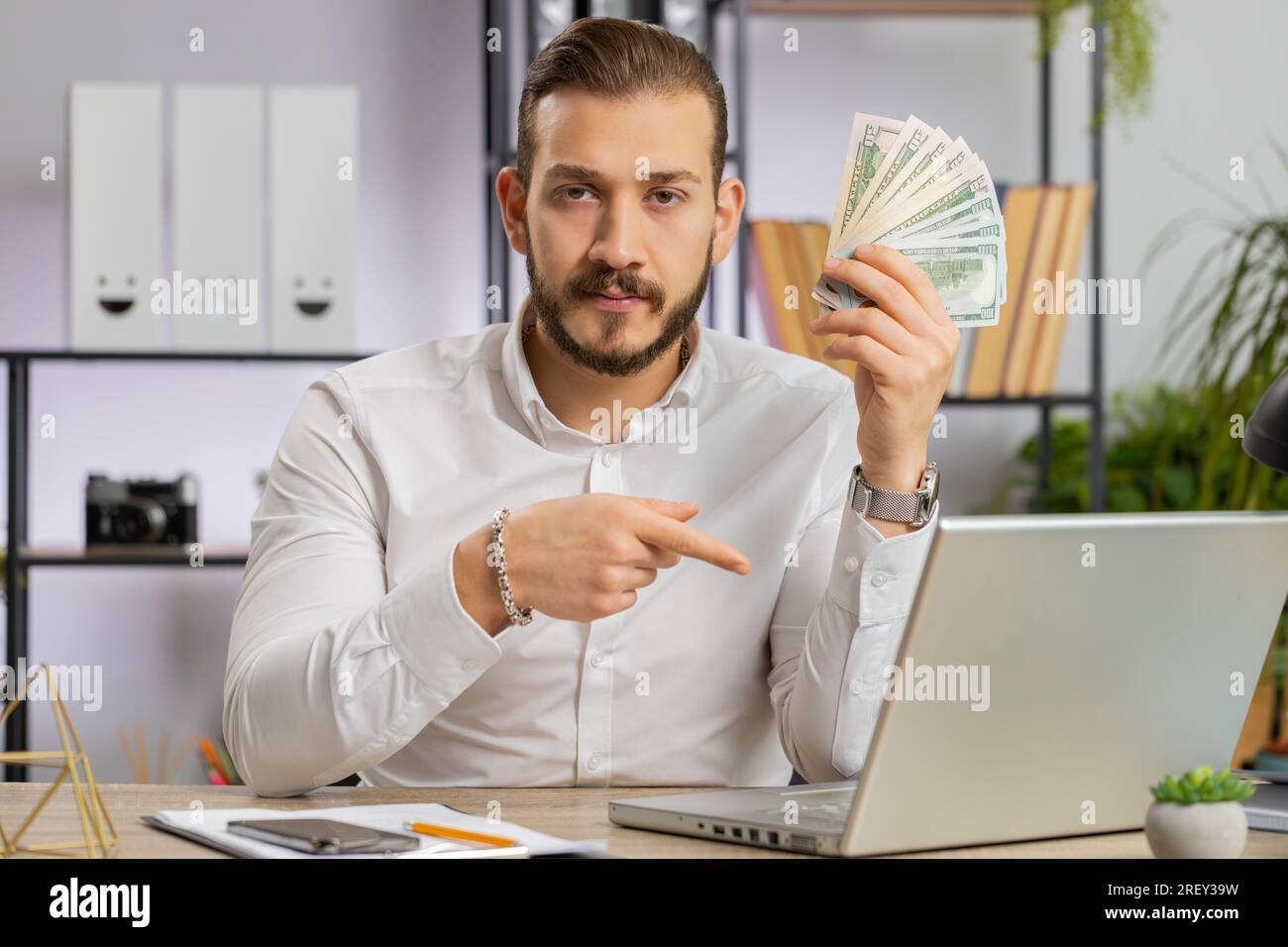 Young middle eastern boss business man showing money dollar cash gives ...