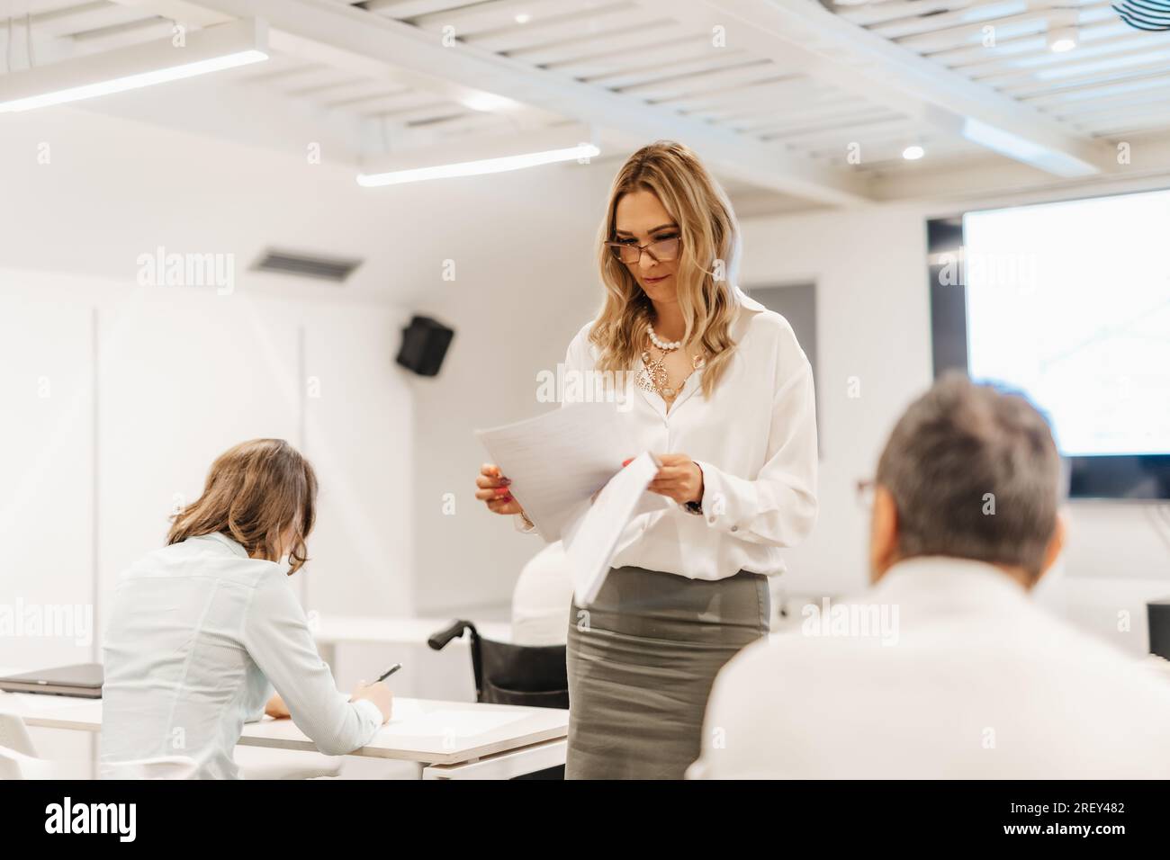Business woman hold paperwork She looks over the documents intently ...