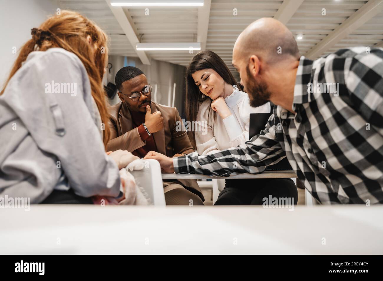 Four multiracial employees working together at the classroom. They are ...