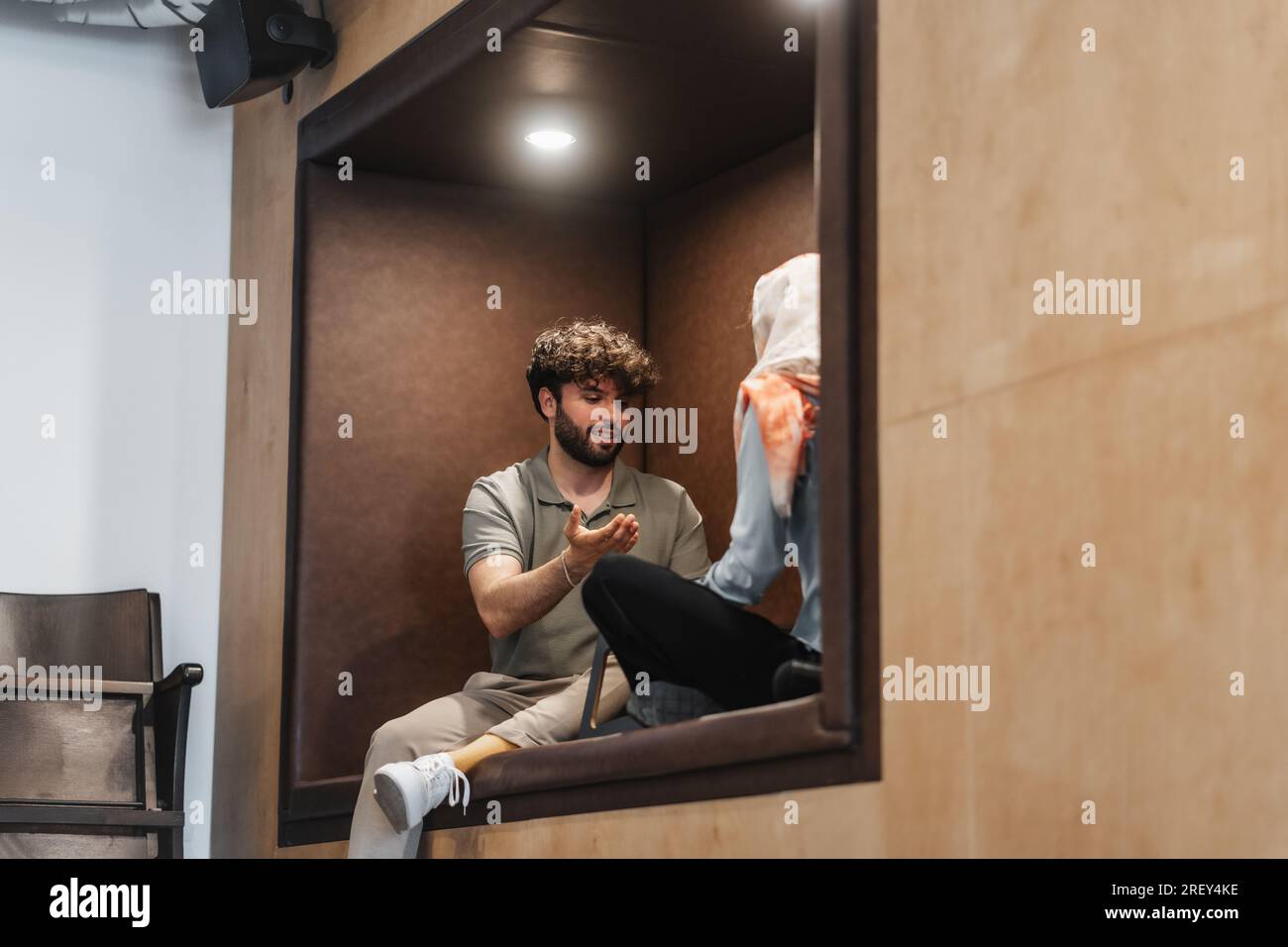 Man smiling while sitting down in a recessed sofa area and playing a ...