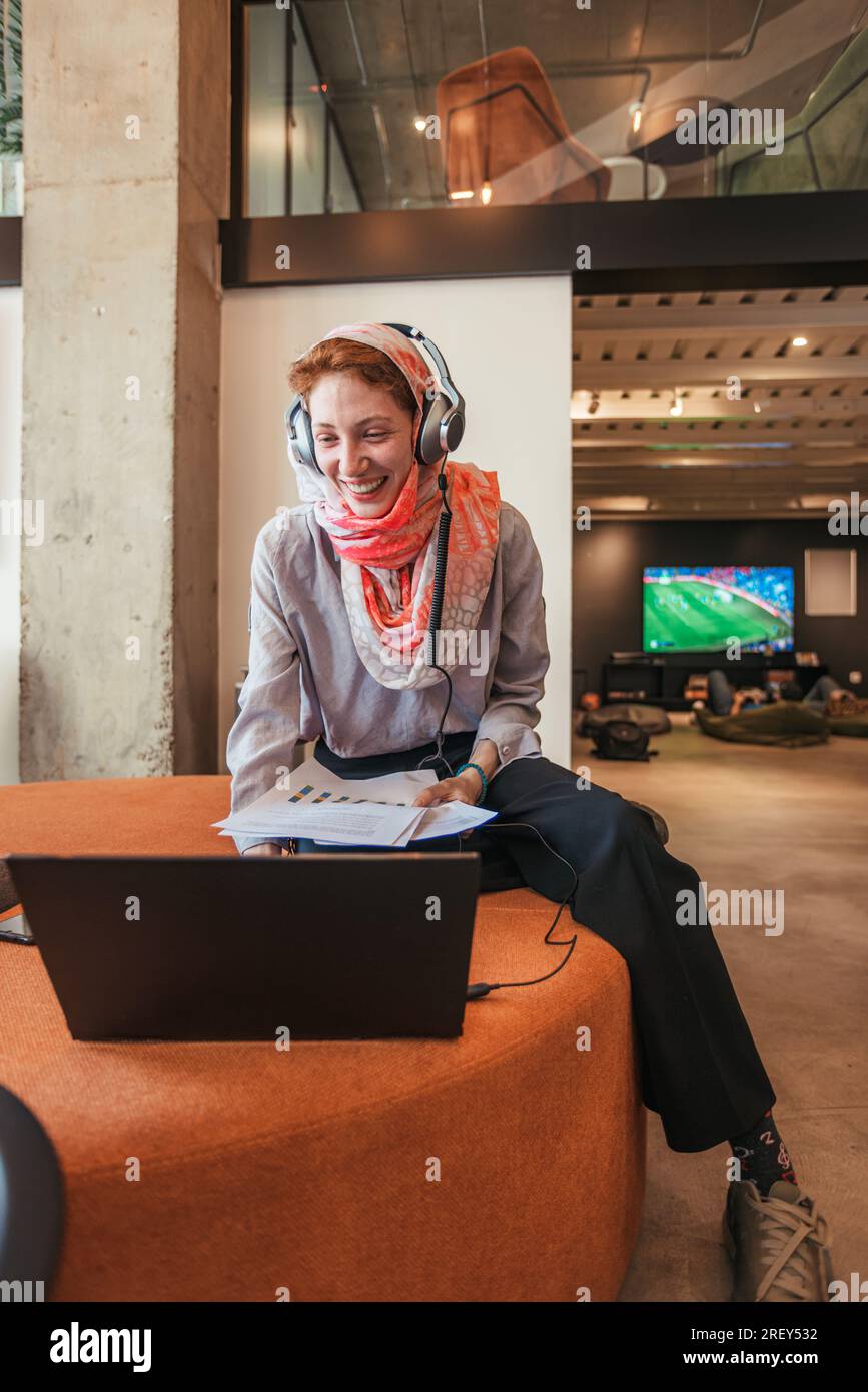 Overjoyed businesswoman in hijab having fun conversation with clients ...