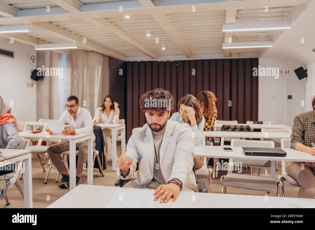 Disabled man in wheelchair having a test after training at work. Inter ...