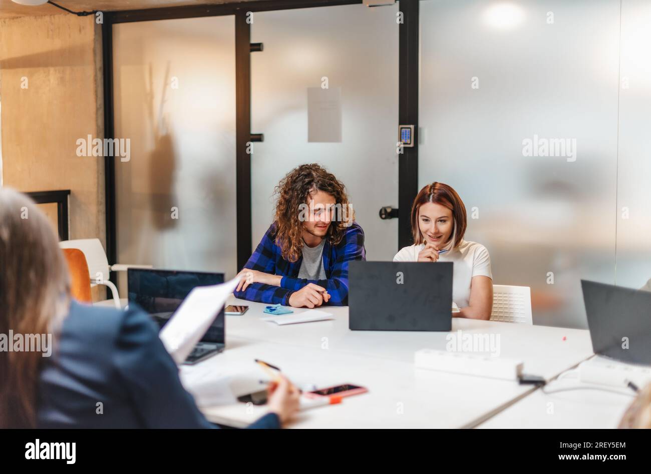Beautiful colleagues, male and female, solving daily tasks at work ...