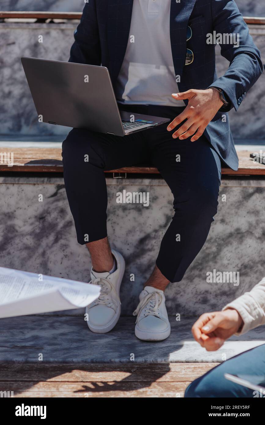Cropped photo of businessman sitting on bench with lap top gestures ...