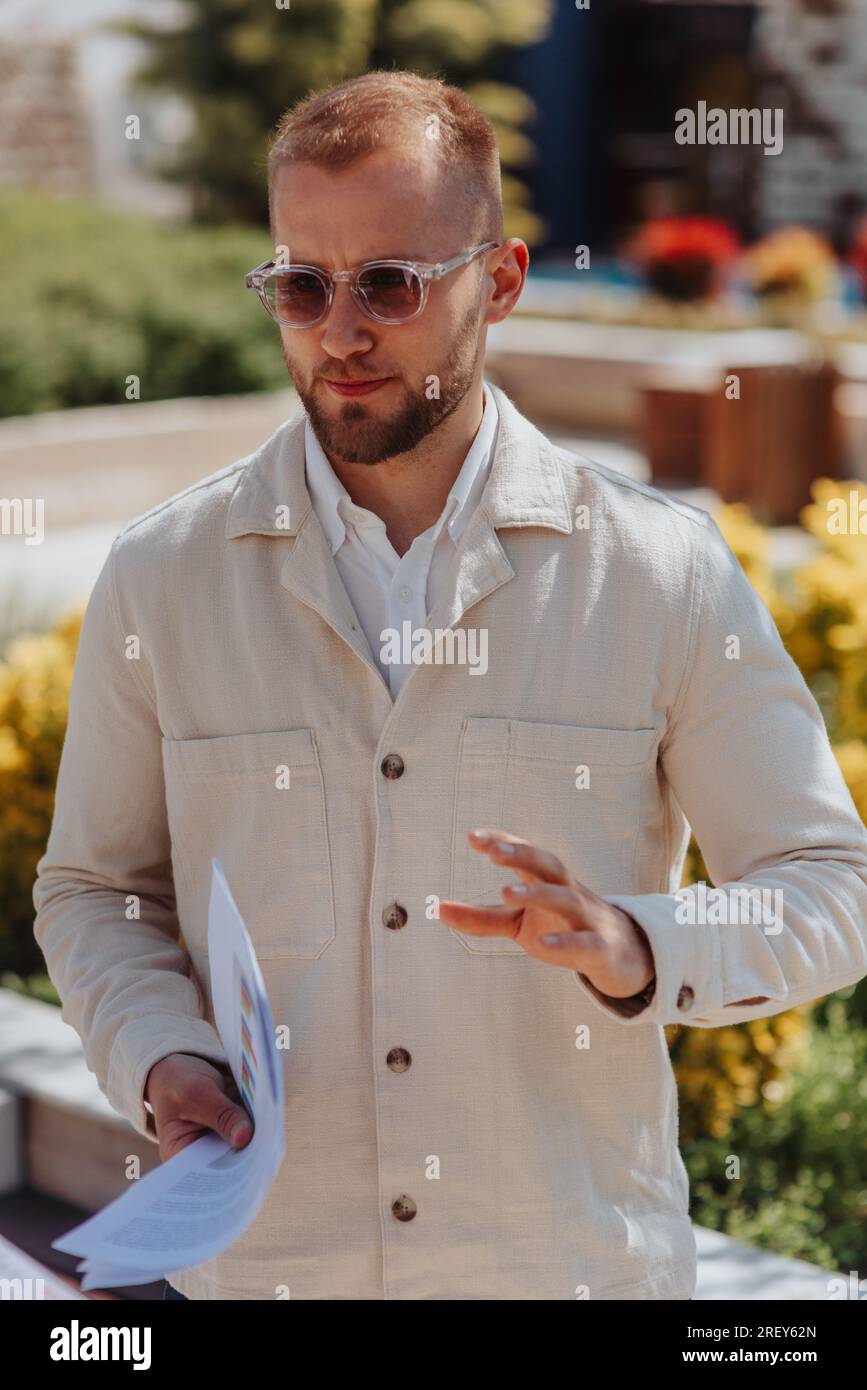 Good looking businessman gesticulating and explaining sales report ...