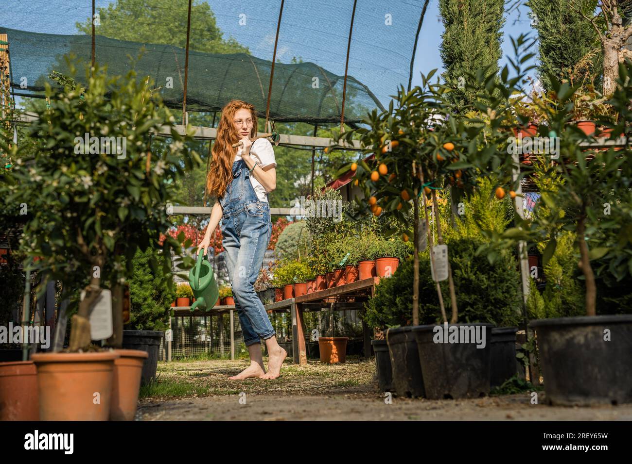 Low angle view shot of lovely garden girl with digger over her shoulder ...