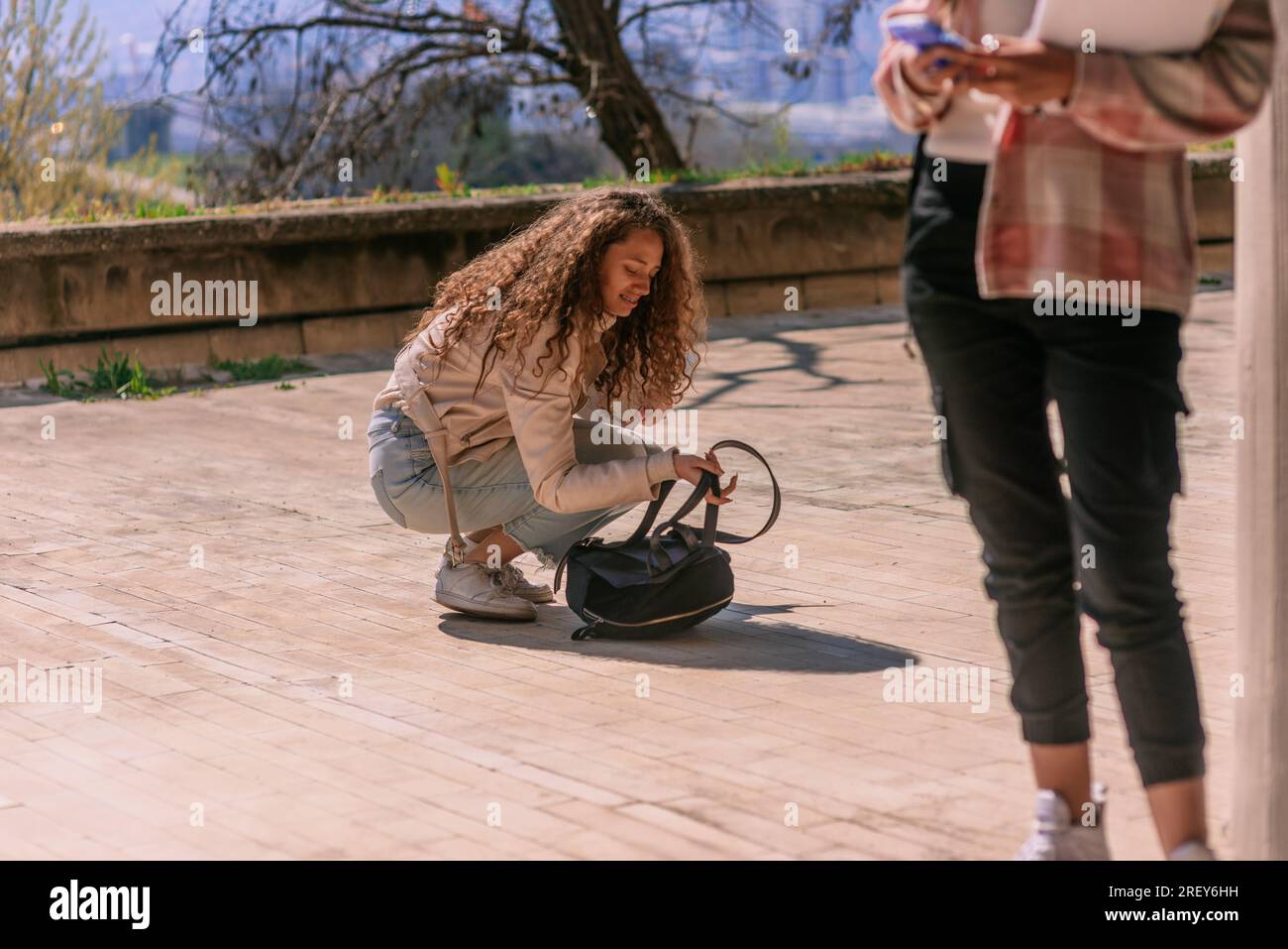 School bag fell down. School girl is picking it up Stock Photo - Alamy