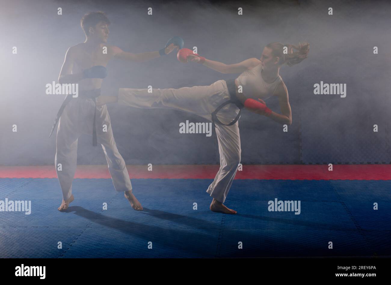 Close up of two young karate friends doing the Ura Mawashi Geri pose at ...