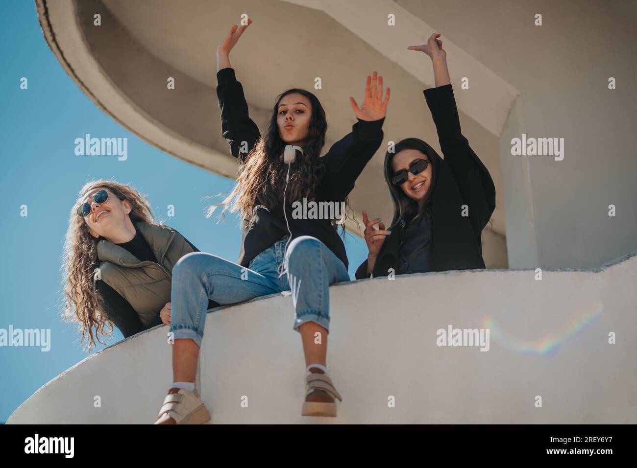 Low angle view of three lovely girls posing for the photographer. They ...