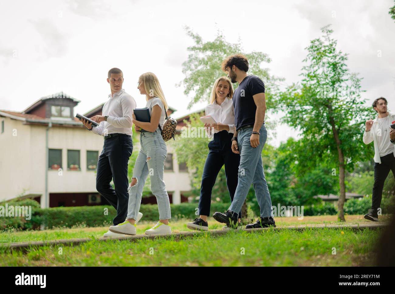 Group of teenage high school students standing outside, talking and ...