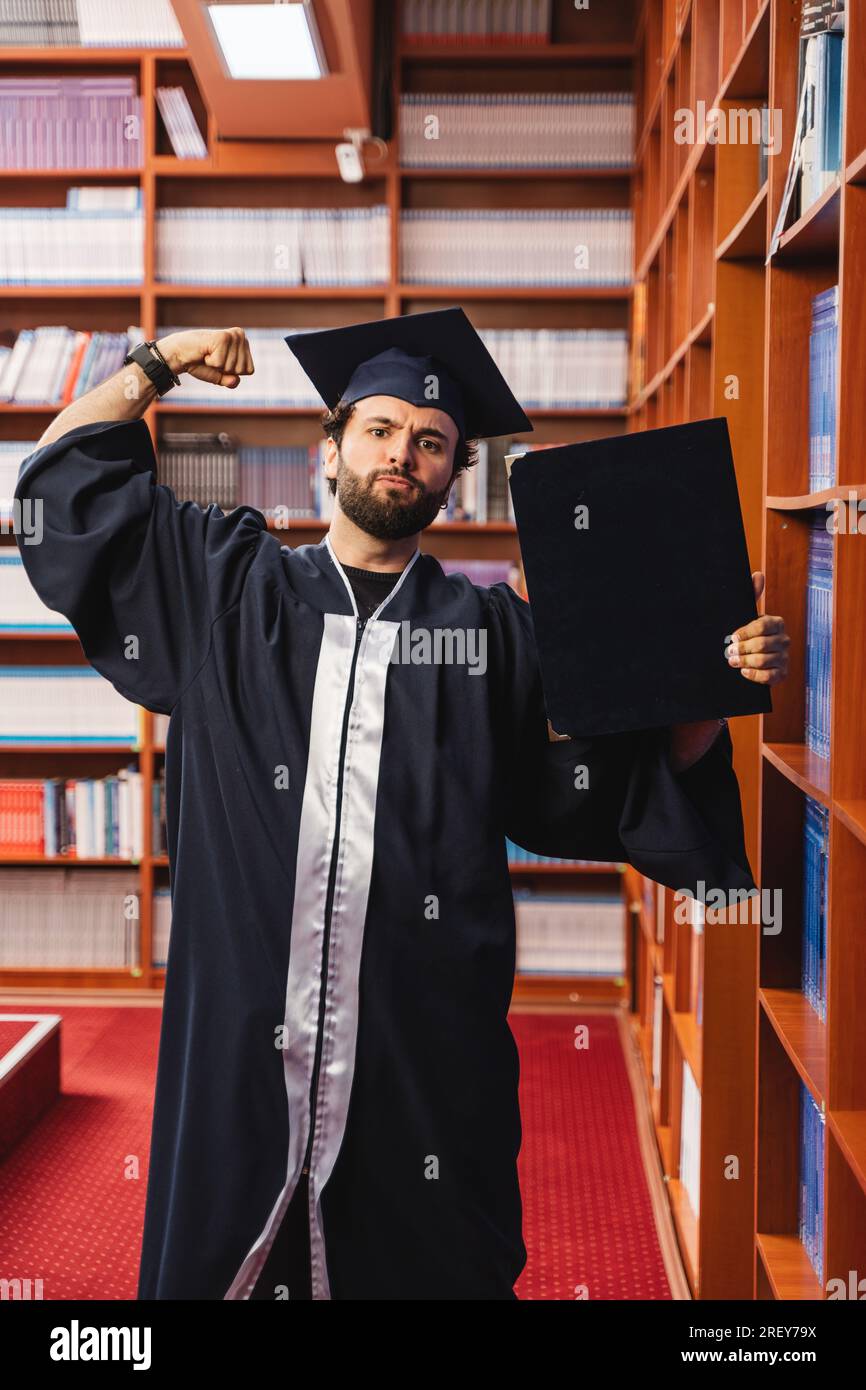 Young male graduate wearing his cap and gown and celebrating on getting ...