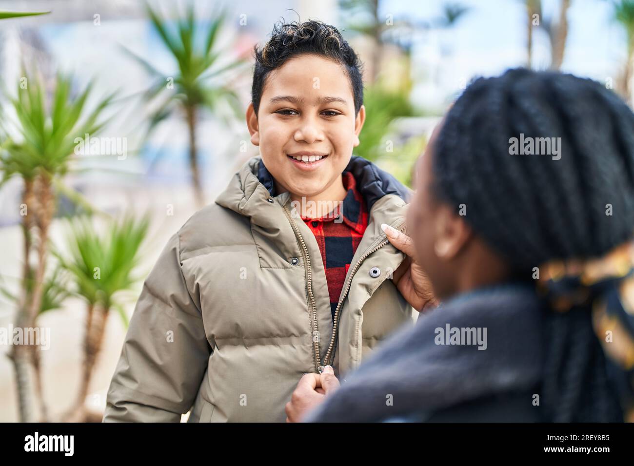 African american mother and son smiling confident closing jacket at ...