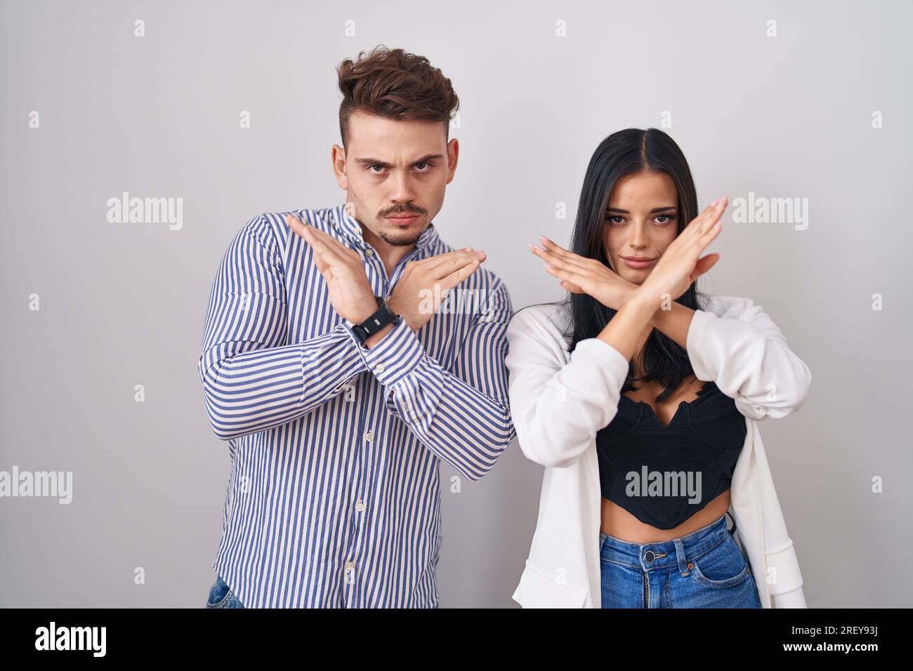 Young hispanic couple standing over white background rejection ...