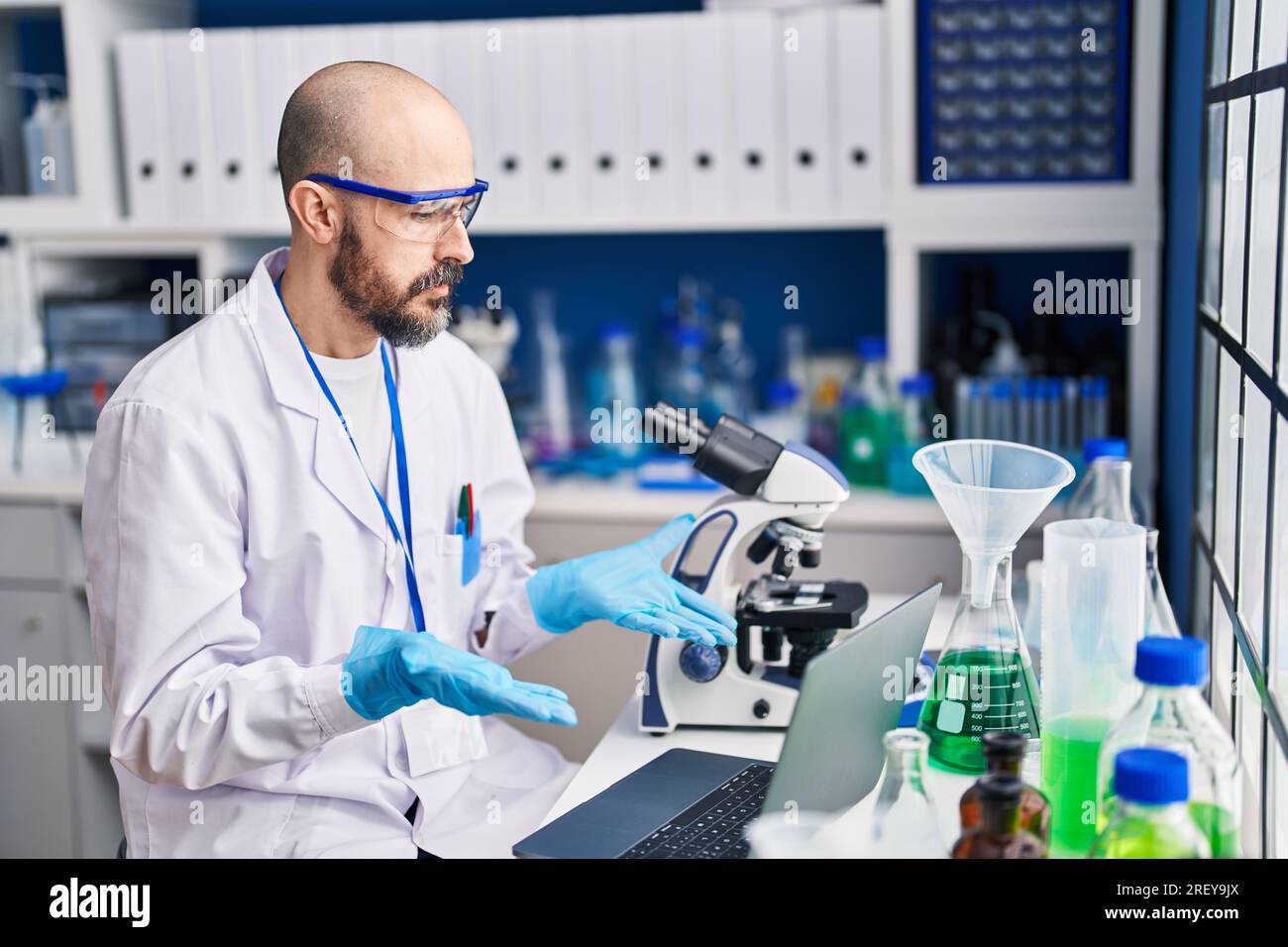 Young bald man scientist having video call at laboratory Stock Photo ...