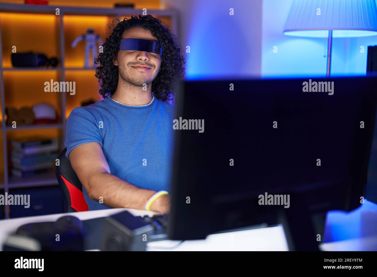 Young latin man streamer playing video game using virtual reality ...