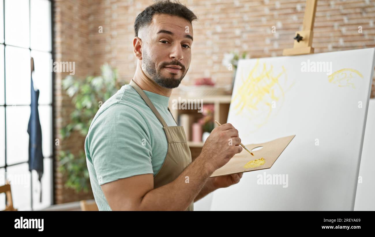 Young arab man artist drawing with serious face at art studio Stock ...