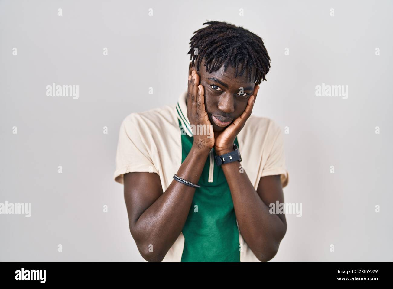African man with dreadlocks standing over isolated background tired ...