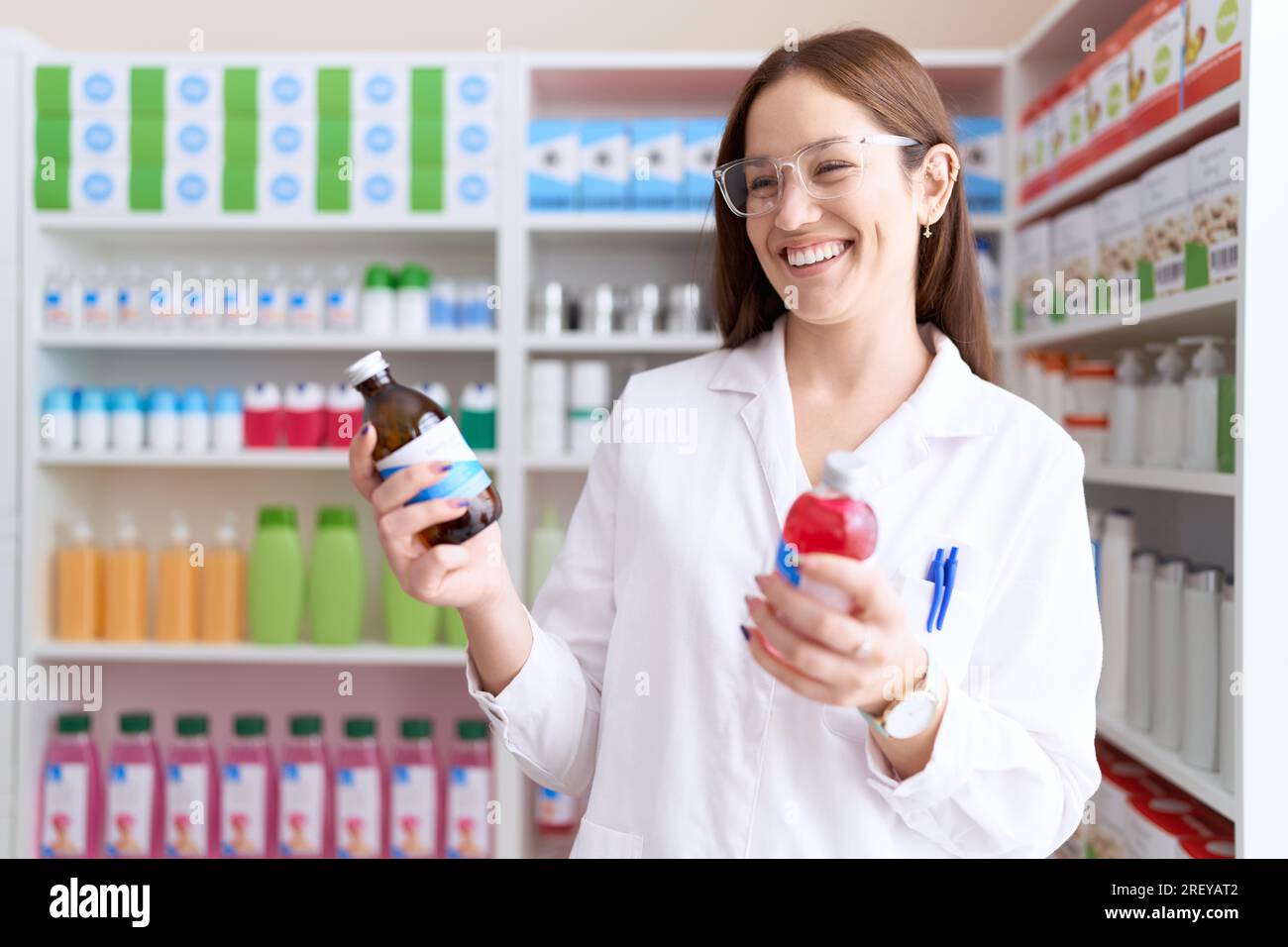 Young beautiful woman pharmacist scanning medication bottle at pharmacy ...