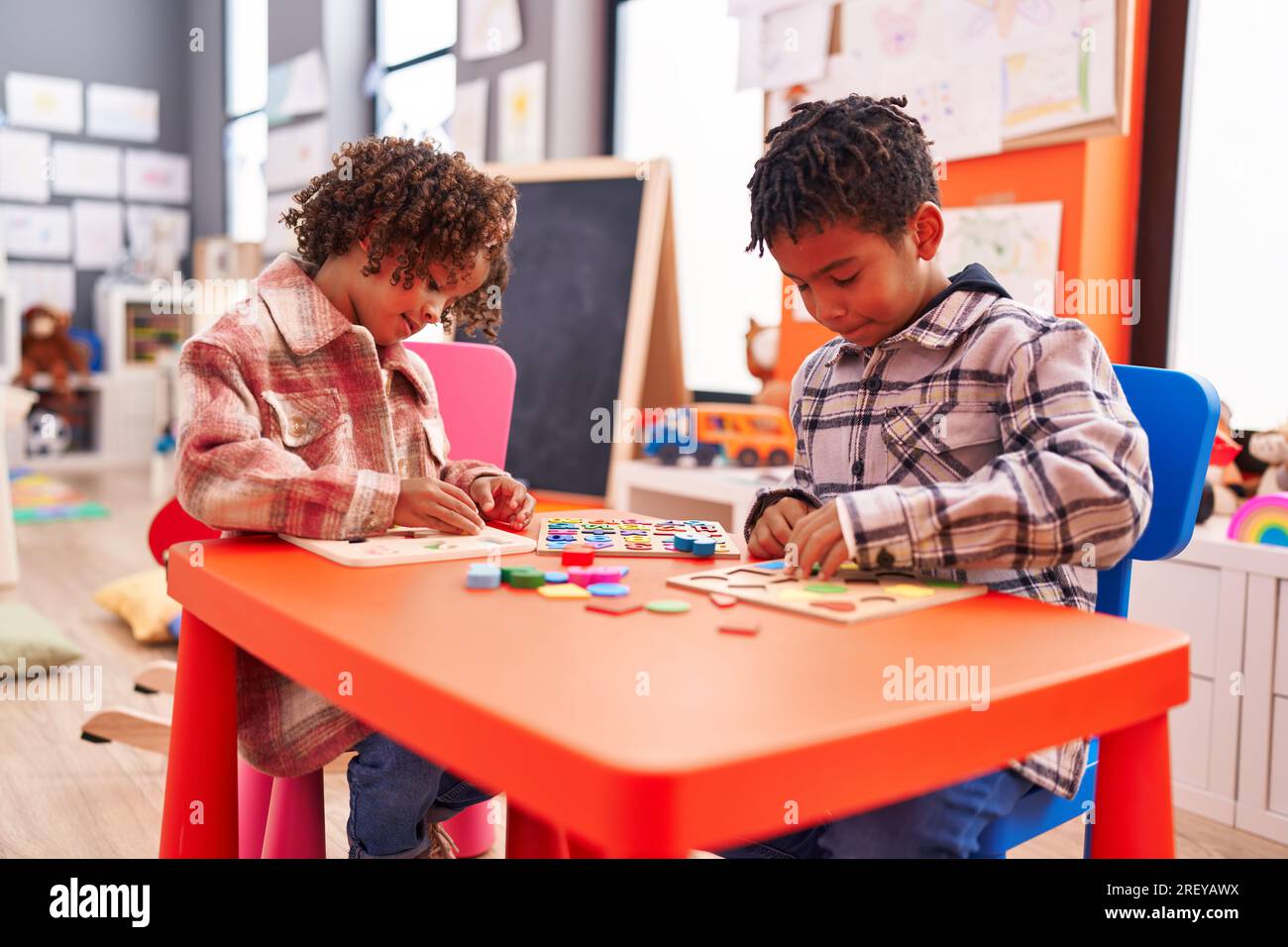 Adorable african american boy and girl playing with maths puzzle game ...