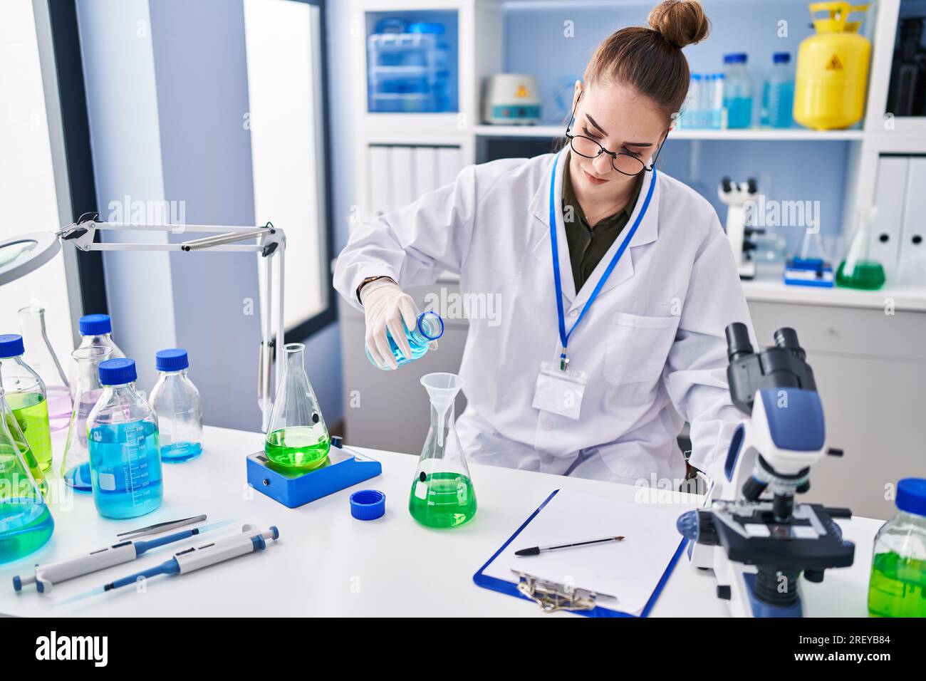 Young woman scientist measuring liquid at laboratory Stock Photo - Alamy