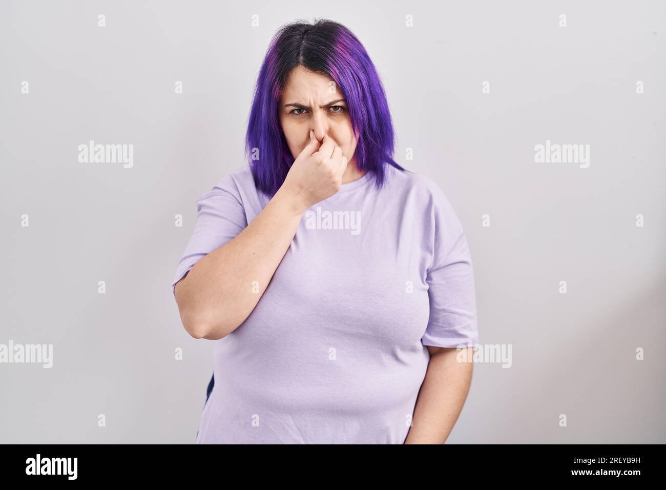 Plus size woman wit purple hair standing over isolated background ...