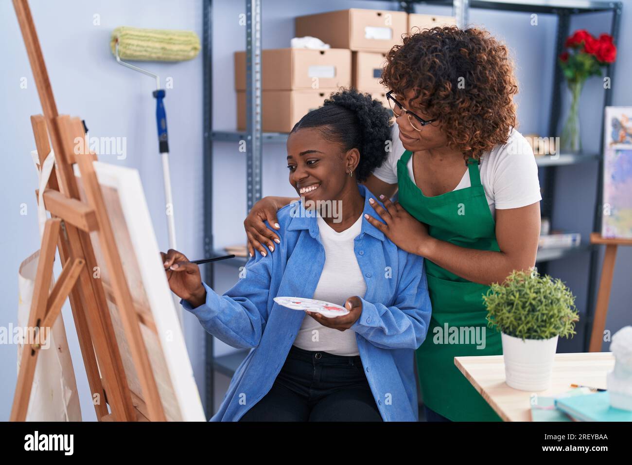 African american women teacher and student artist drawing at art studio ...