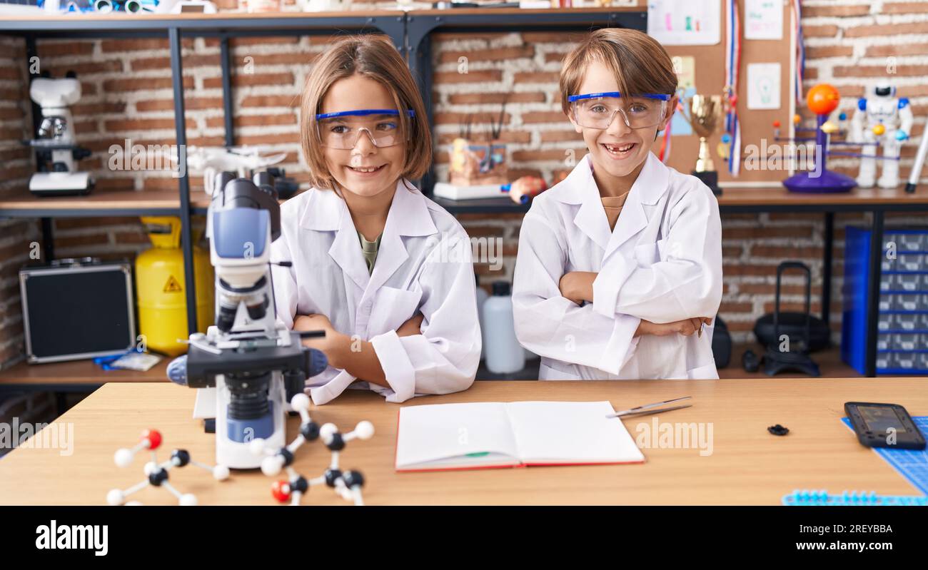 Adorable boys students standing with arms crossed gesture at laboratory ...