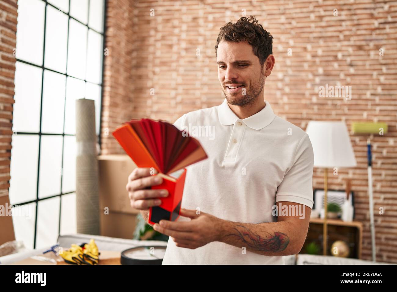 Young hispanic man choosing paint color standing at new home Stock ...