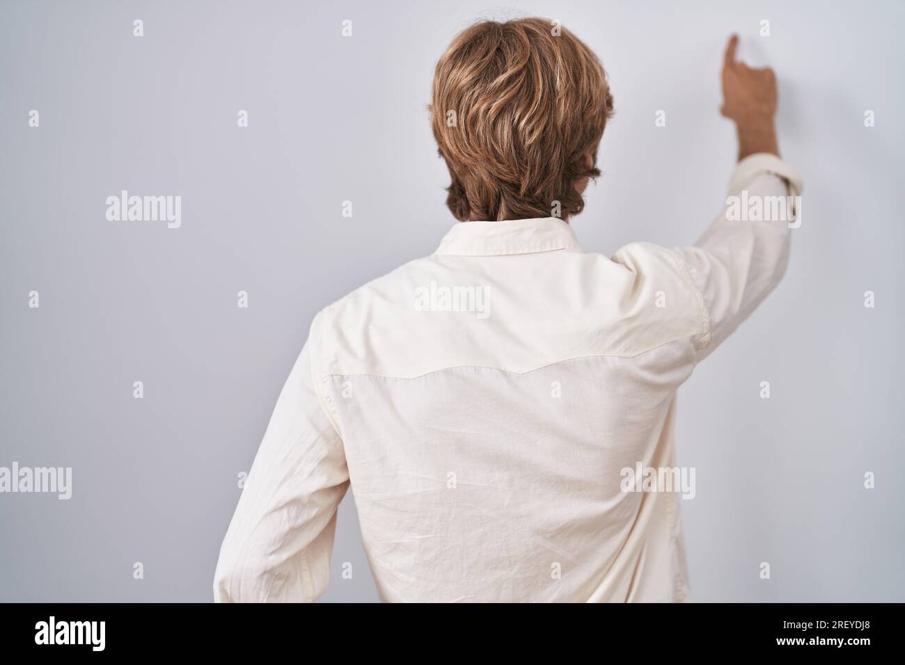 Middle age man standing over isolated background posing backwards ...