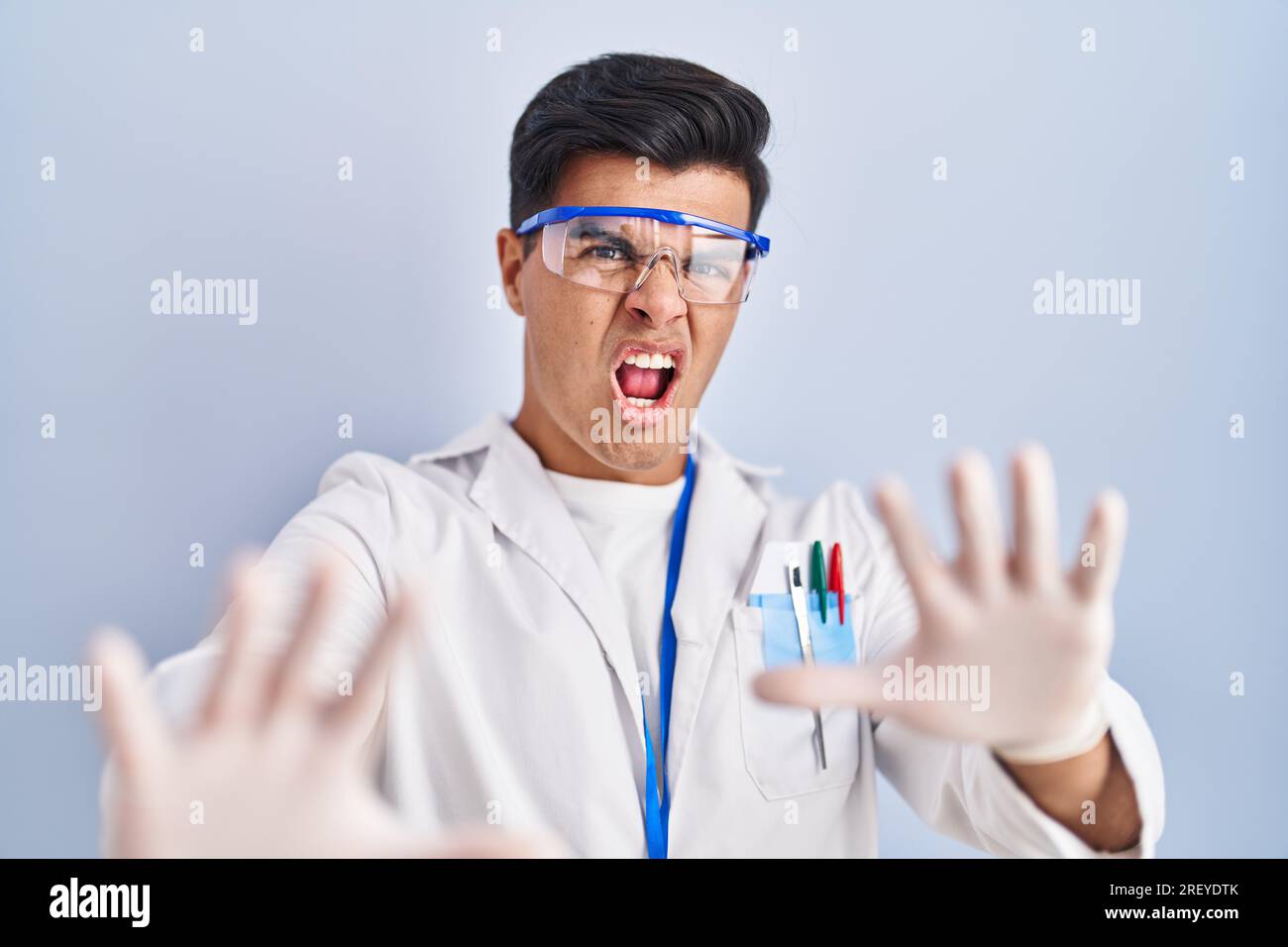 Hispanic man working as scientist afraid and terrified with fear ...