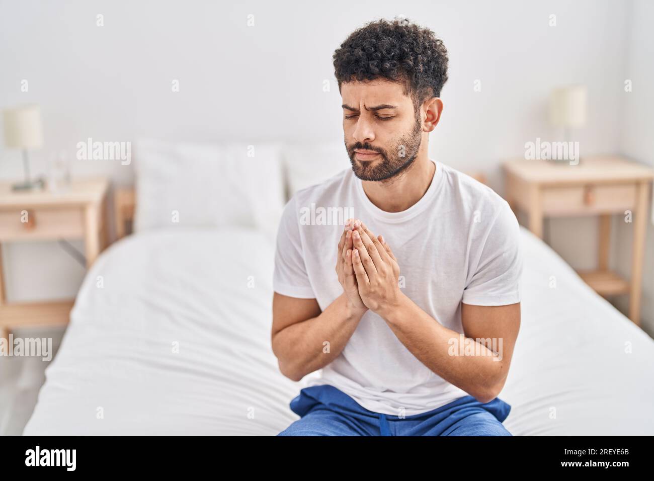 Young arab man praying sitting on bed at bedroom Stock Photo - Alamy