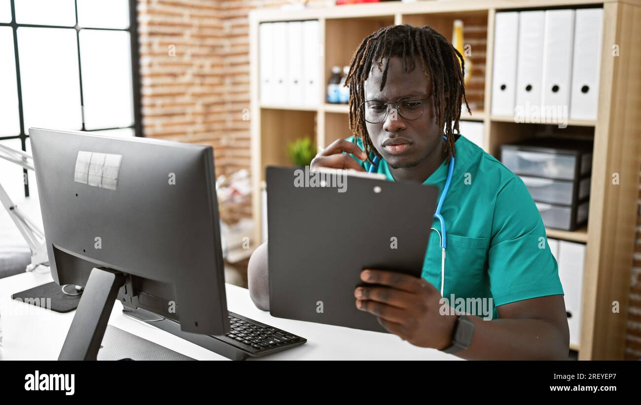 African american man doctor using computer reading medical report at ... African american man doctor using computer reading medical report at ...